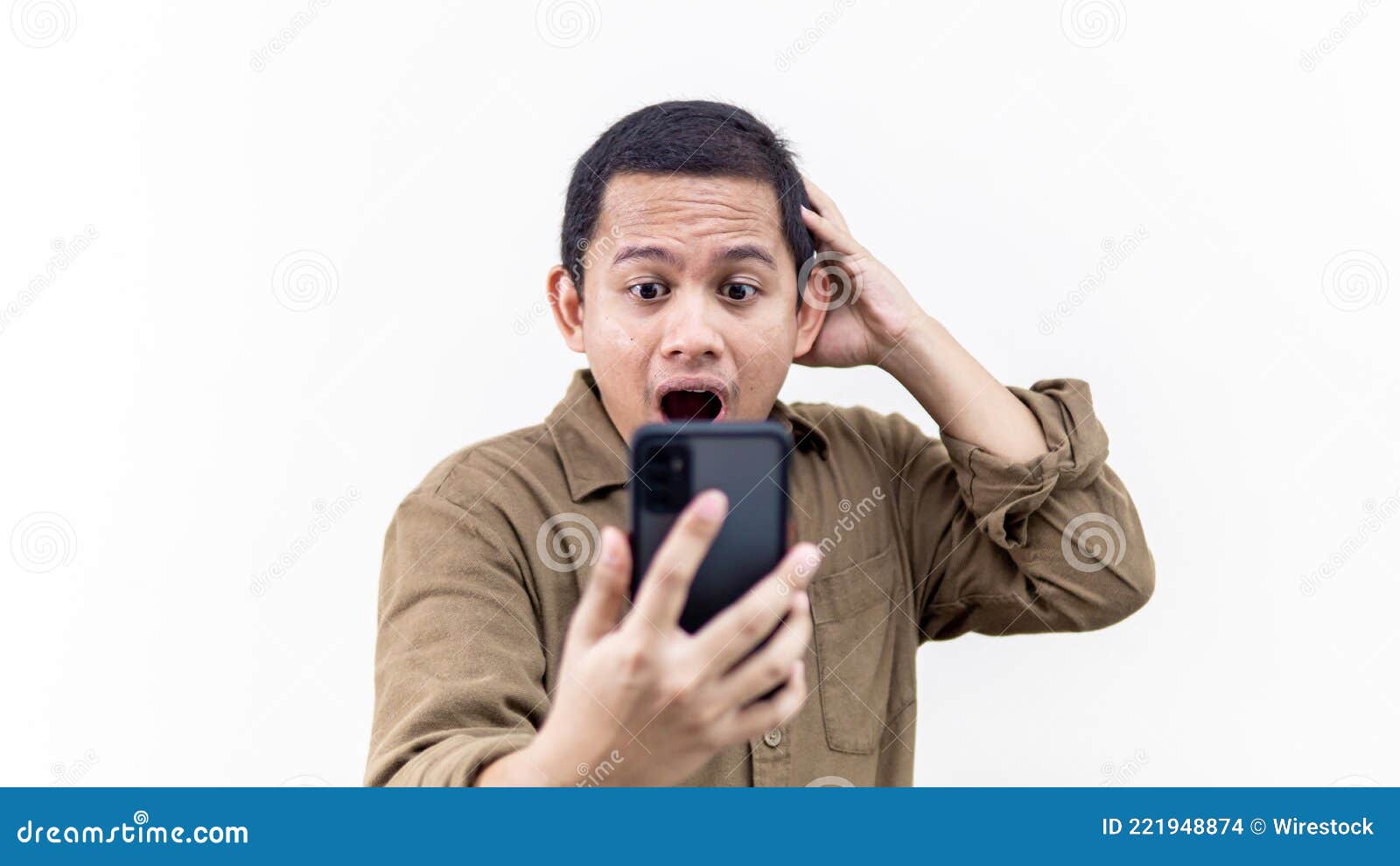 Young Malay with His Hand on His Head Looking at the Smartphone with a ...