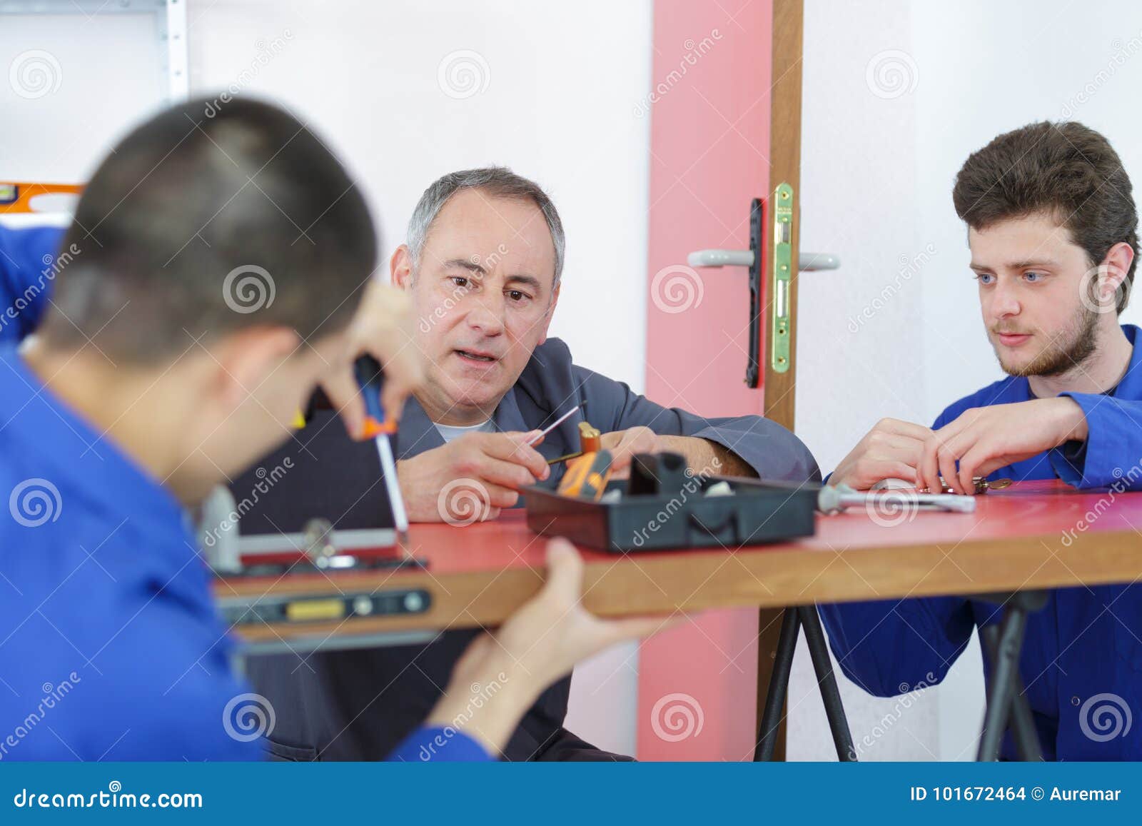 Young Male Apprentices Fixing Door with Screwdriver Stock Photo - Image ...