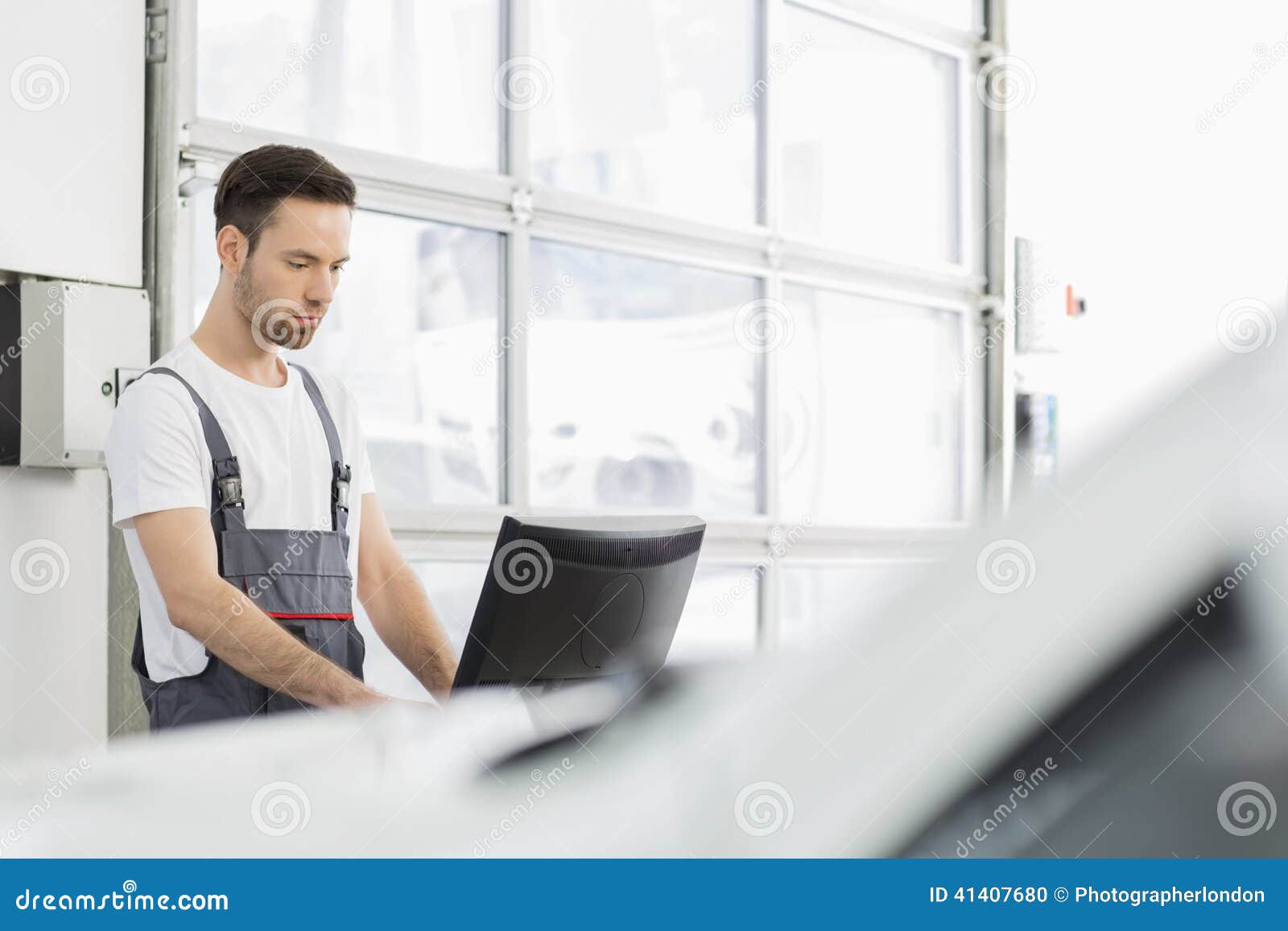 Young Male Automobile Mechanic Using Computer in Repair Shop Stock ...
