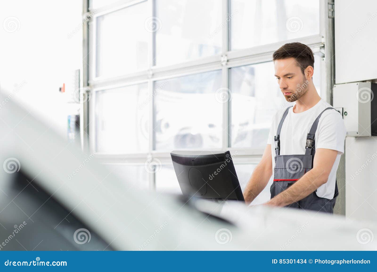 Young Male Automobile Mechanic Using Computer in Repair Shop Stock ...