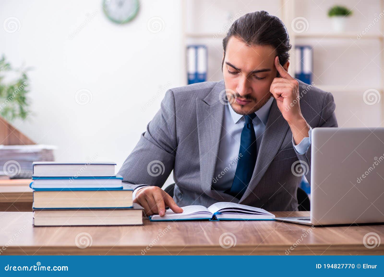 Young Male Businessman Reading Books at Workplace Stock Photo - Image ...