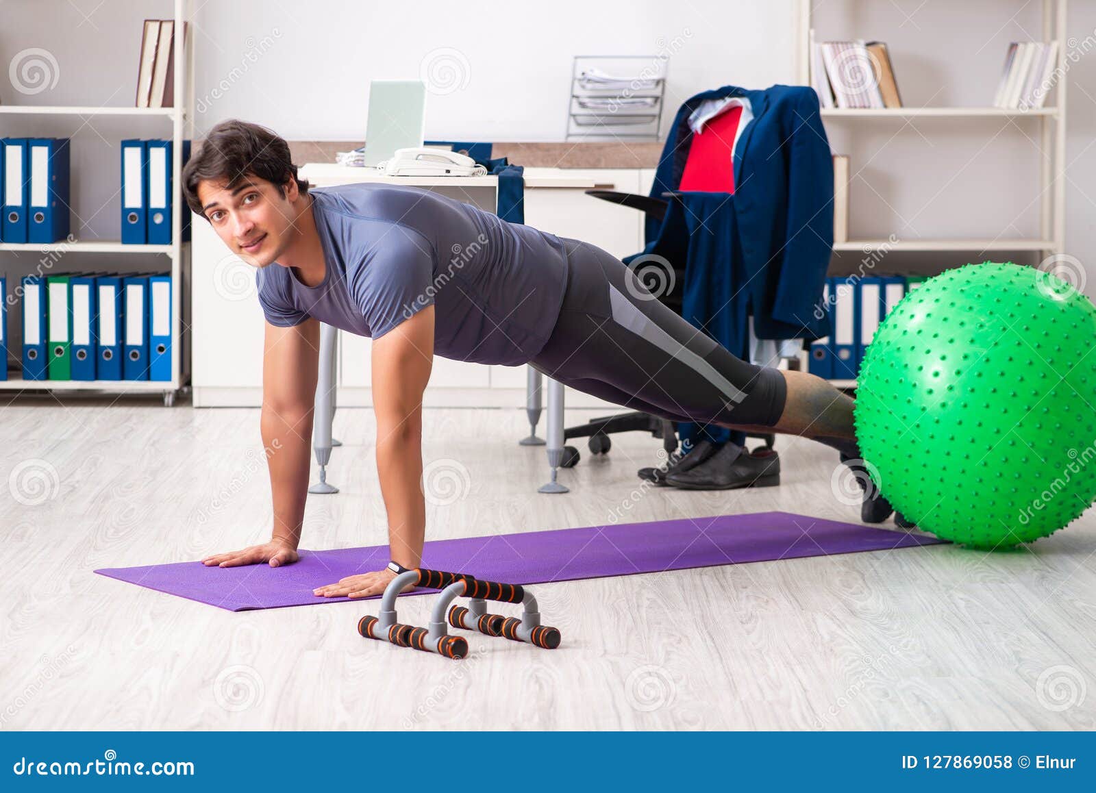 The Young Male Employee Exercising in the Office Stock Photo - Image of ...