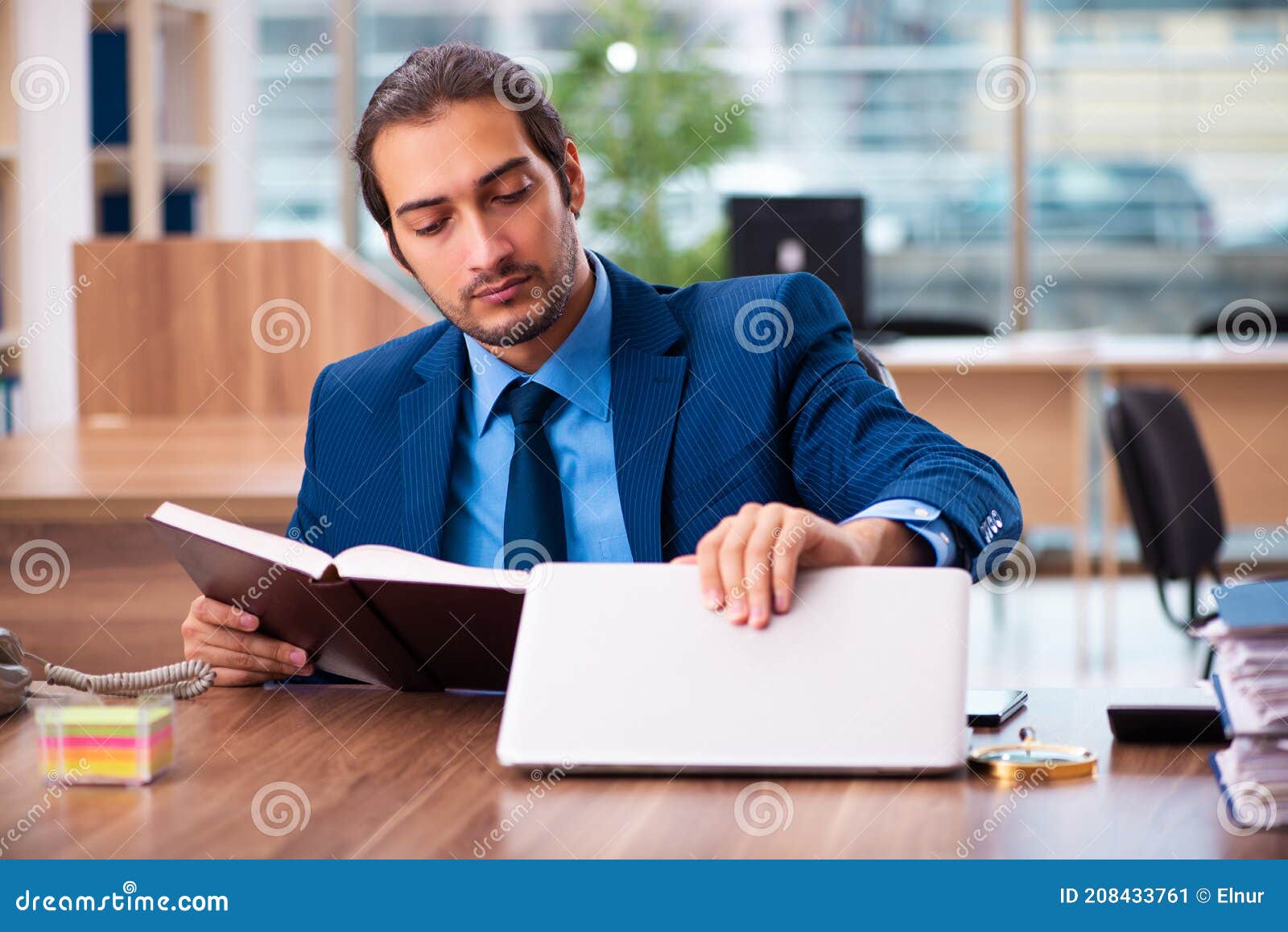 Young Male Employee Reading Book in the Office Stock Image - Image of ...