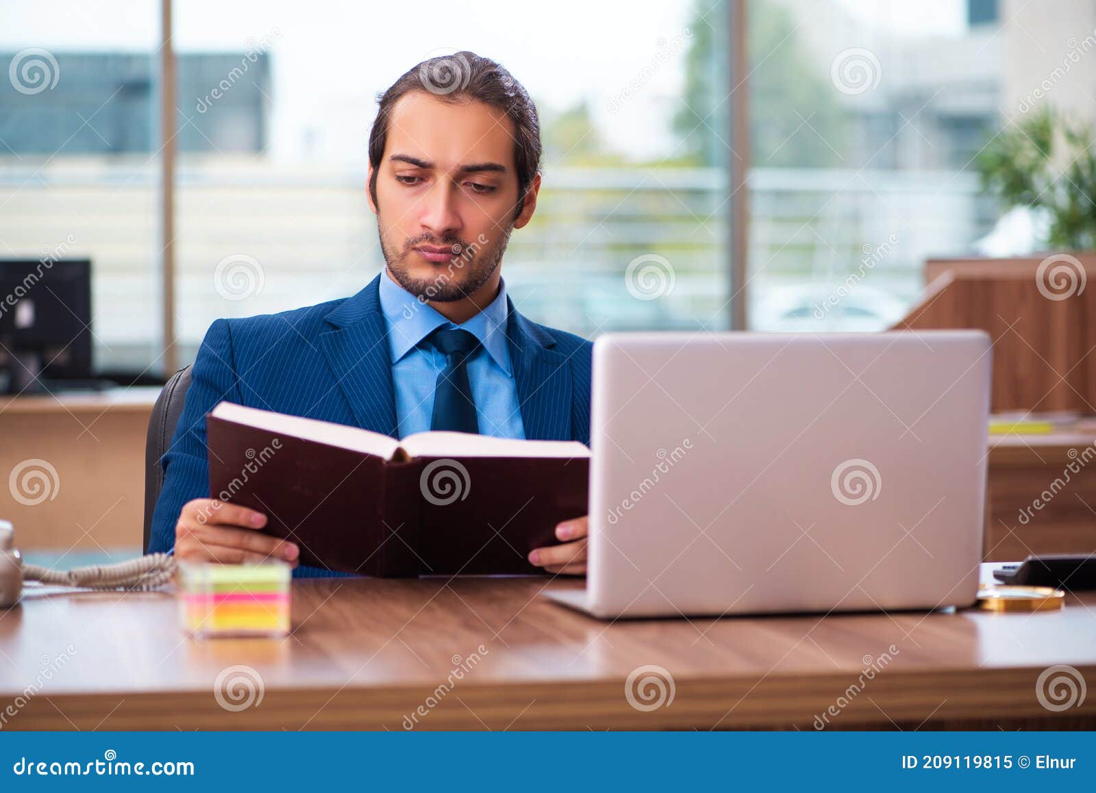 Young Male Employee Reading Book in the Office Stock Image - Image of ...