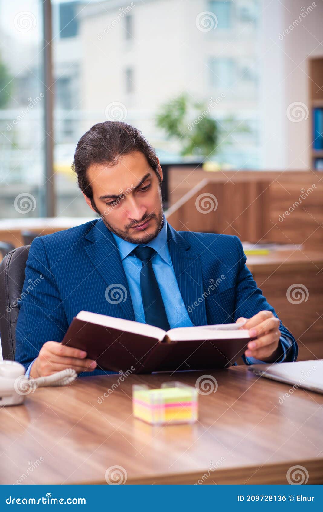 Young Male Employee Reading Book in the Office Stock Photo - Image of ...