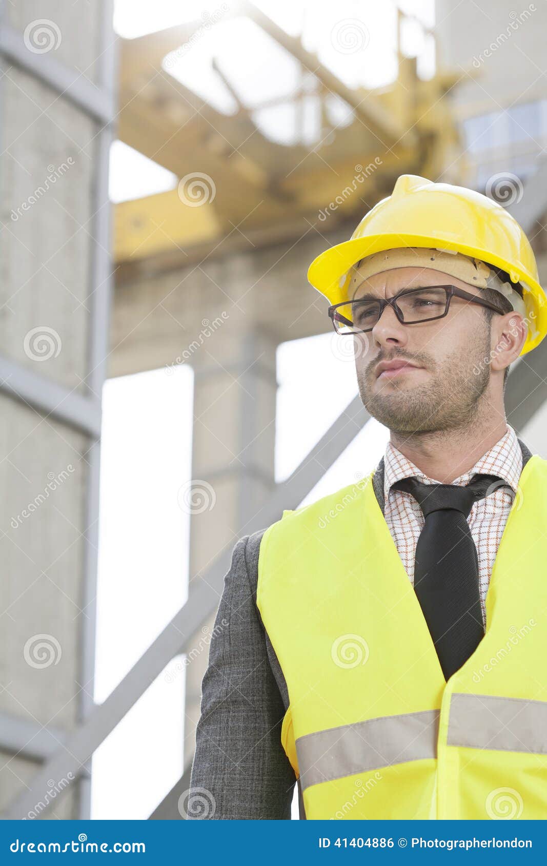 Young Male Engineer Wearing Hard Hat Looking Away at Construction Site ...