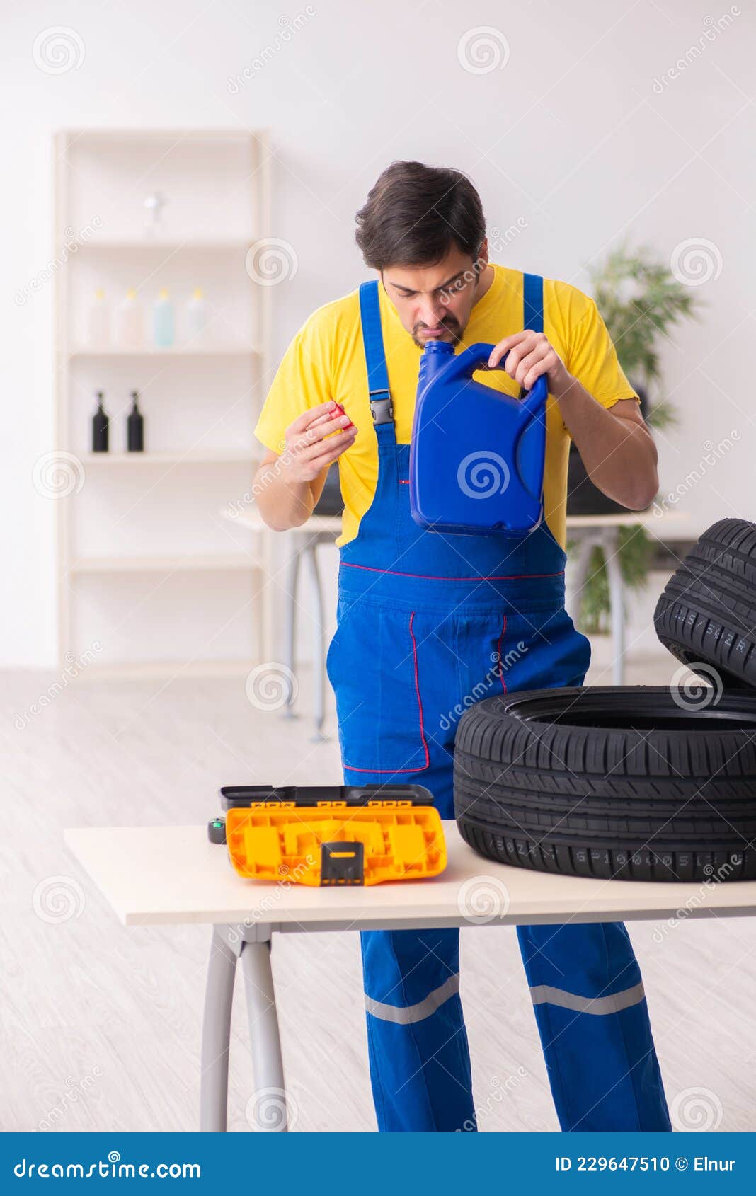 Young Male Garage Worker with Tyre at Workshop Stock Photo - Image of ...
