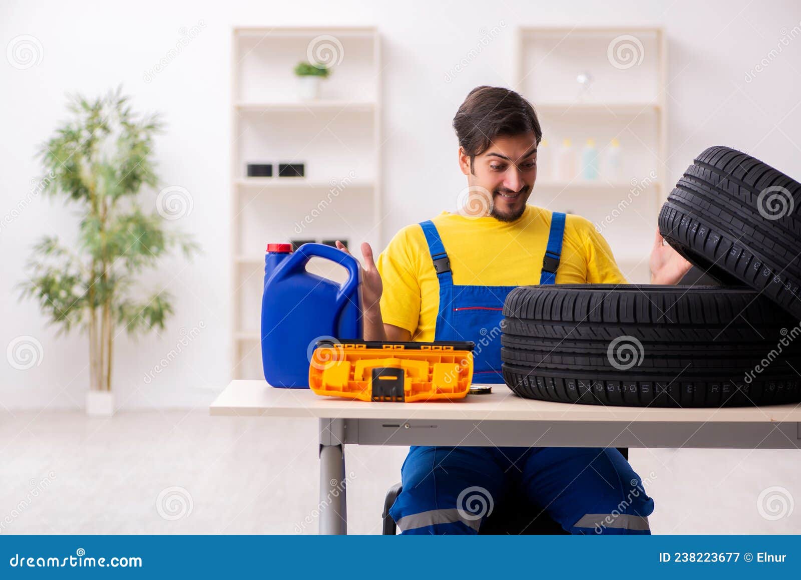 Young Male Garage Worker with Tyre at Workshop Stock Image - Image of ...