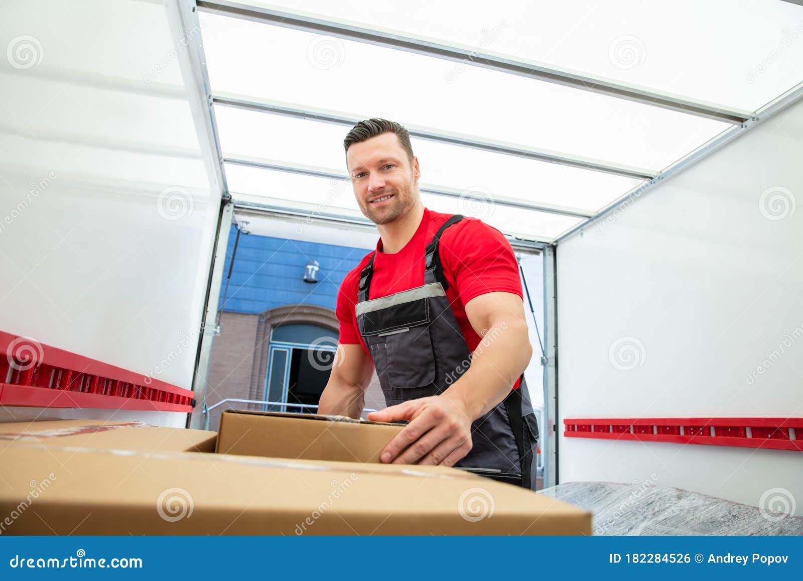 Young Male Mover Arranging the Boxes Inside the Van Stock Photo - Image ...