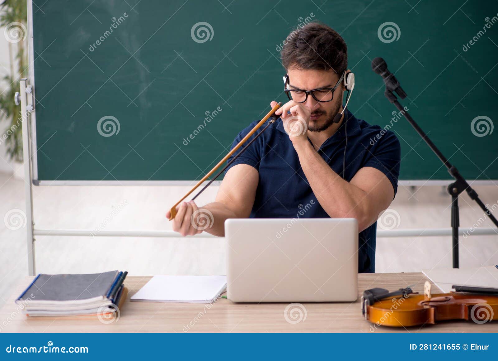 Young Male Music Teacher Sitting in the Classroom Stock Image - Image ...