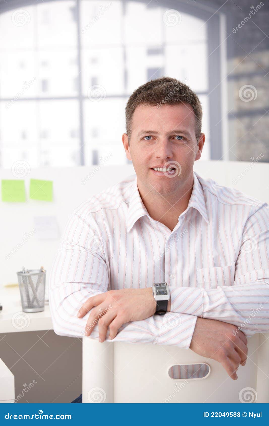 Young Male Office Worker Sitting in Office Smiling Stock Photo - Image ...