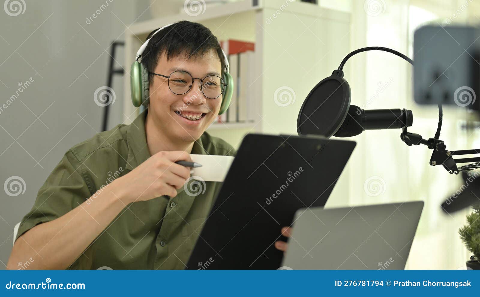 Young Male Podcaster Using a Microphone and Laptop Computer Recording ...