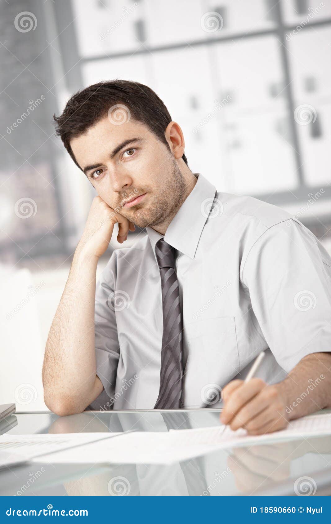 Young Male Sitting at Desk Writing Notes Thinking Stock Photo - Image ...