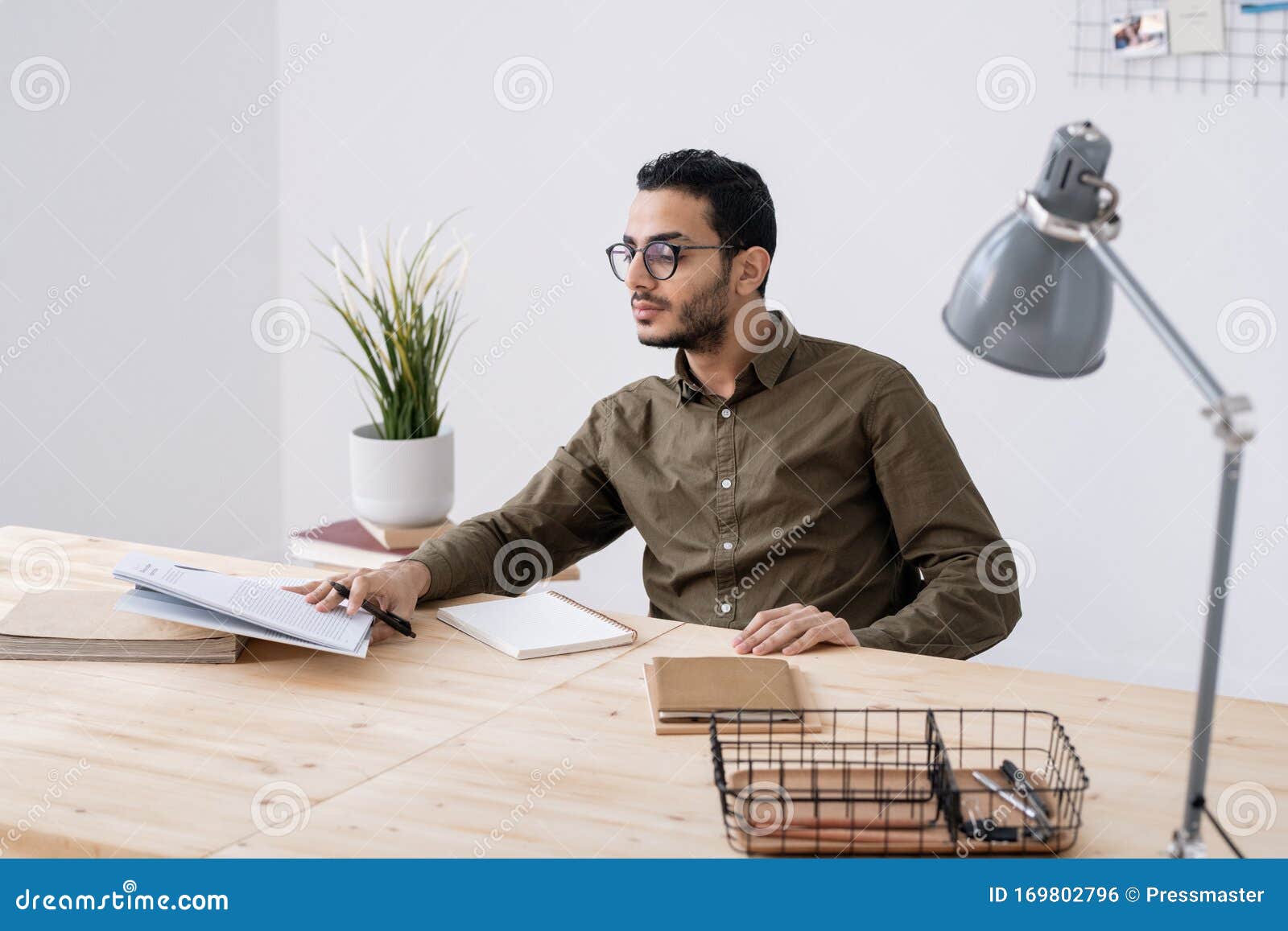 Young Male Student in Eyeglasses Looking at His Notes in Notepad Stock ...