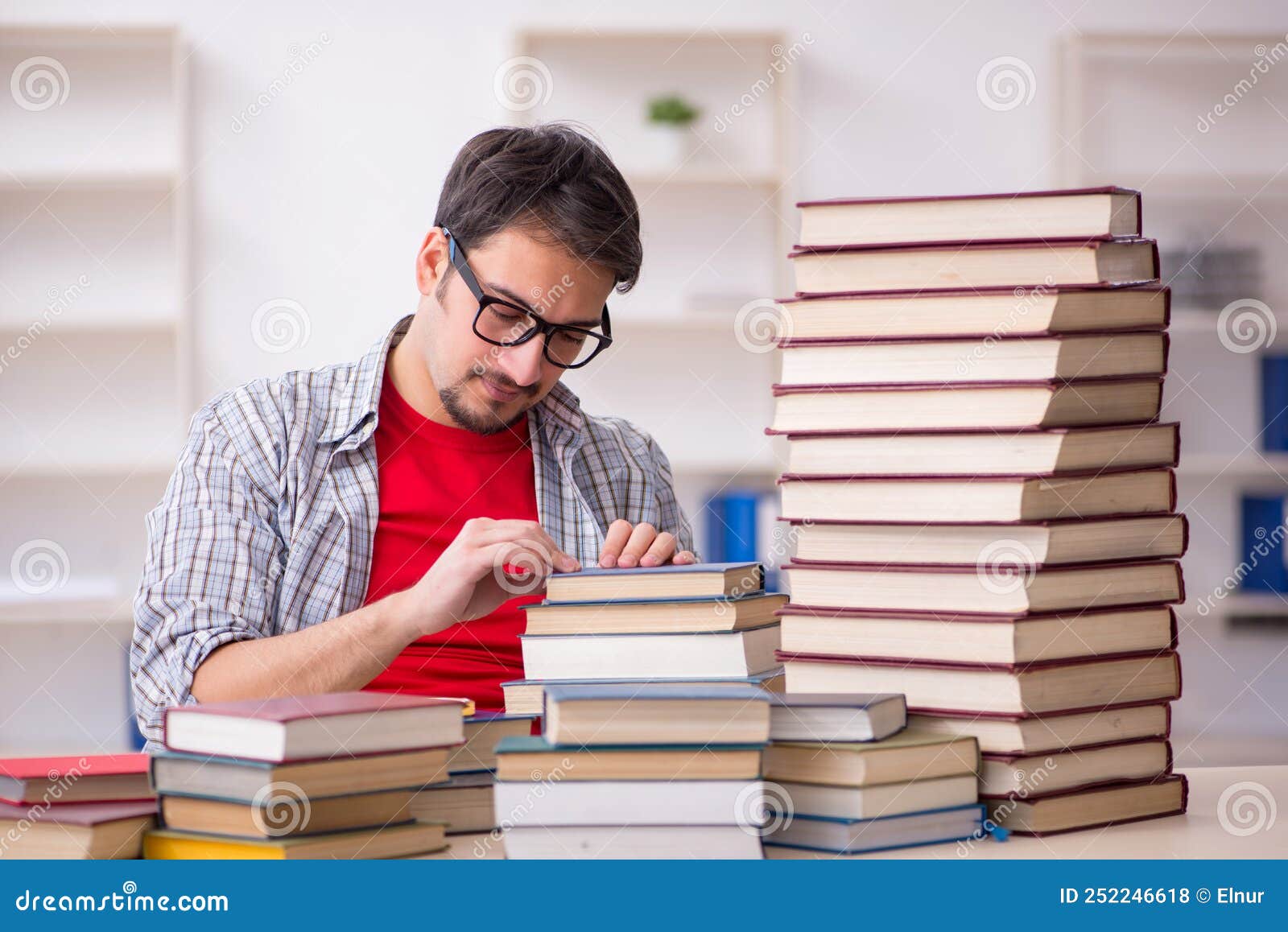 Young Male Student and Too Many Books in the Classroom Stock Photo ...