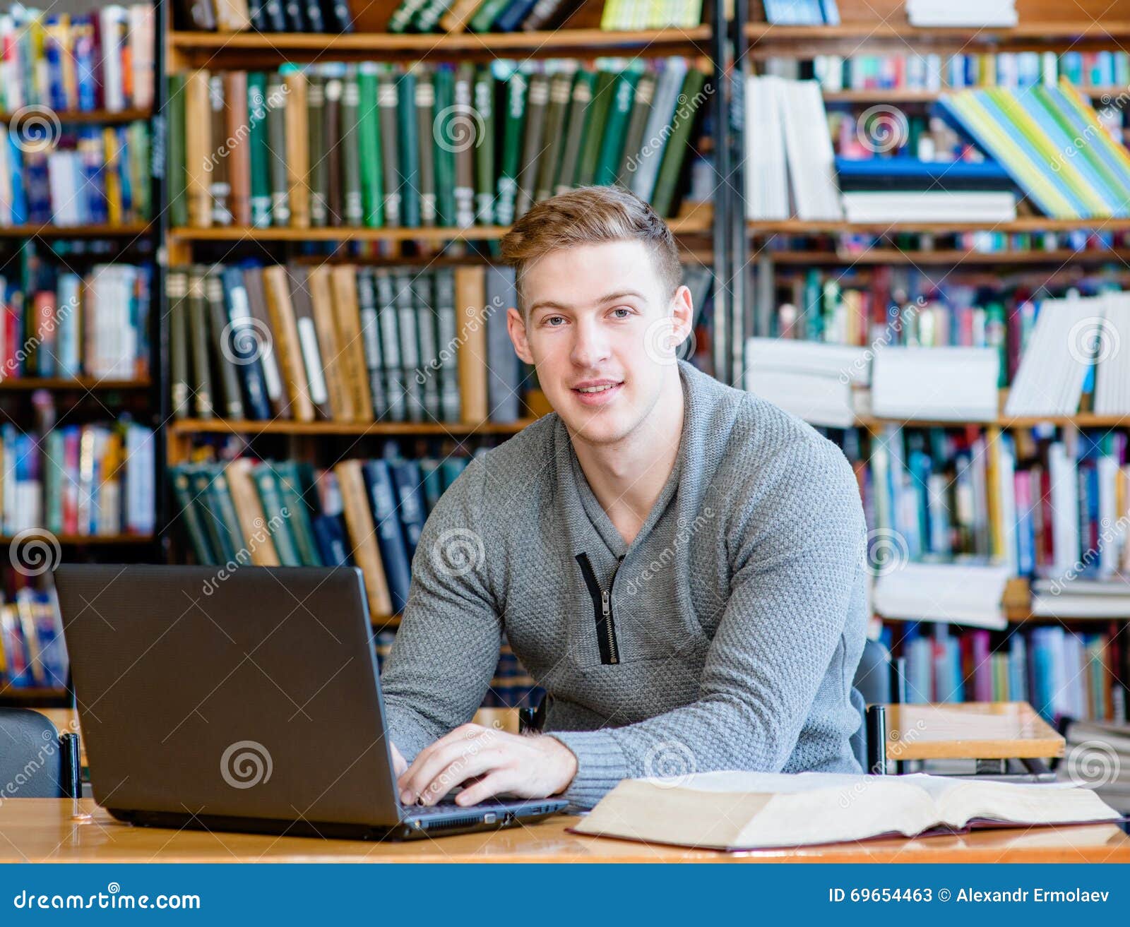 Young Male Student Typing on Laptop in the University Library Stock ...