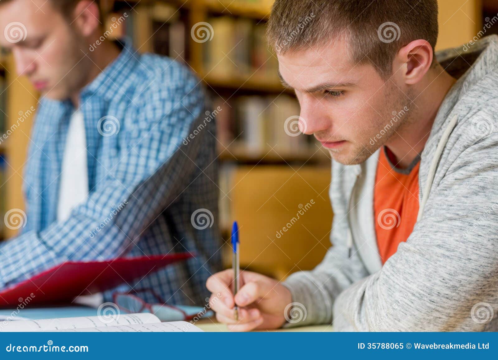 Young Male Students Writing Notes at Library Desk Stock Image - Image ...