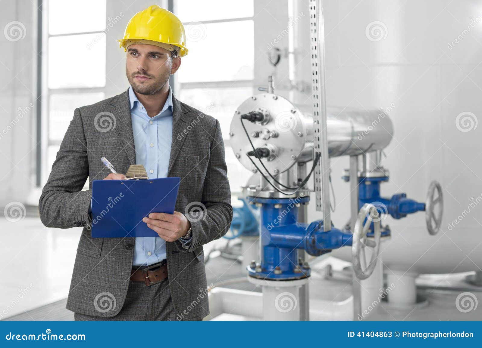Young Male Supervisor Writing on Clipboard in Industry Stock Image ...