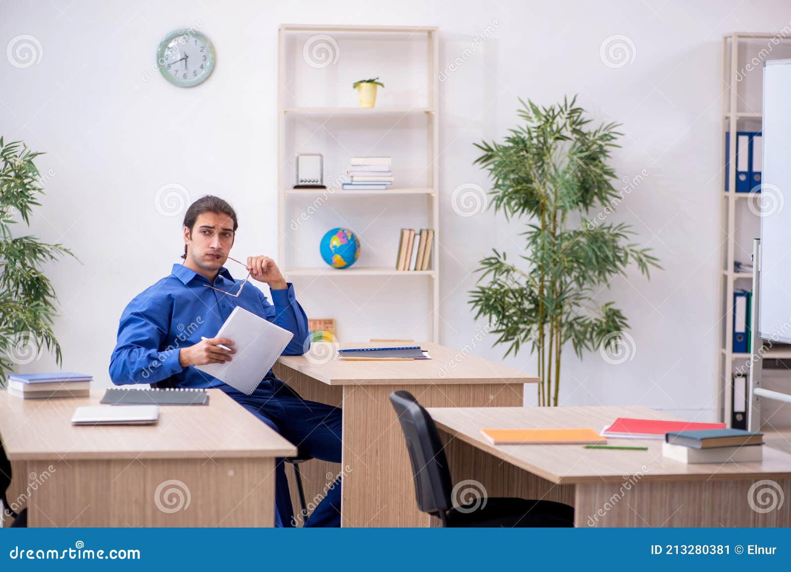 Young Male Teacher Checking Notes in the Classroom Stock Image - Image ...