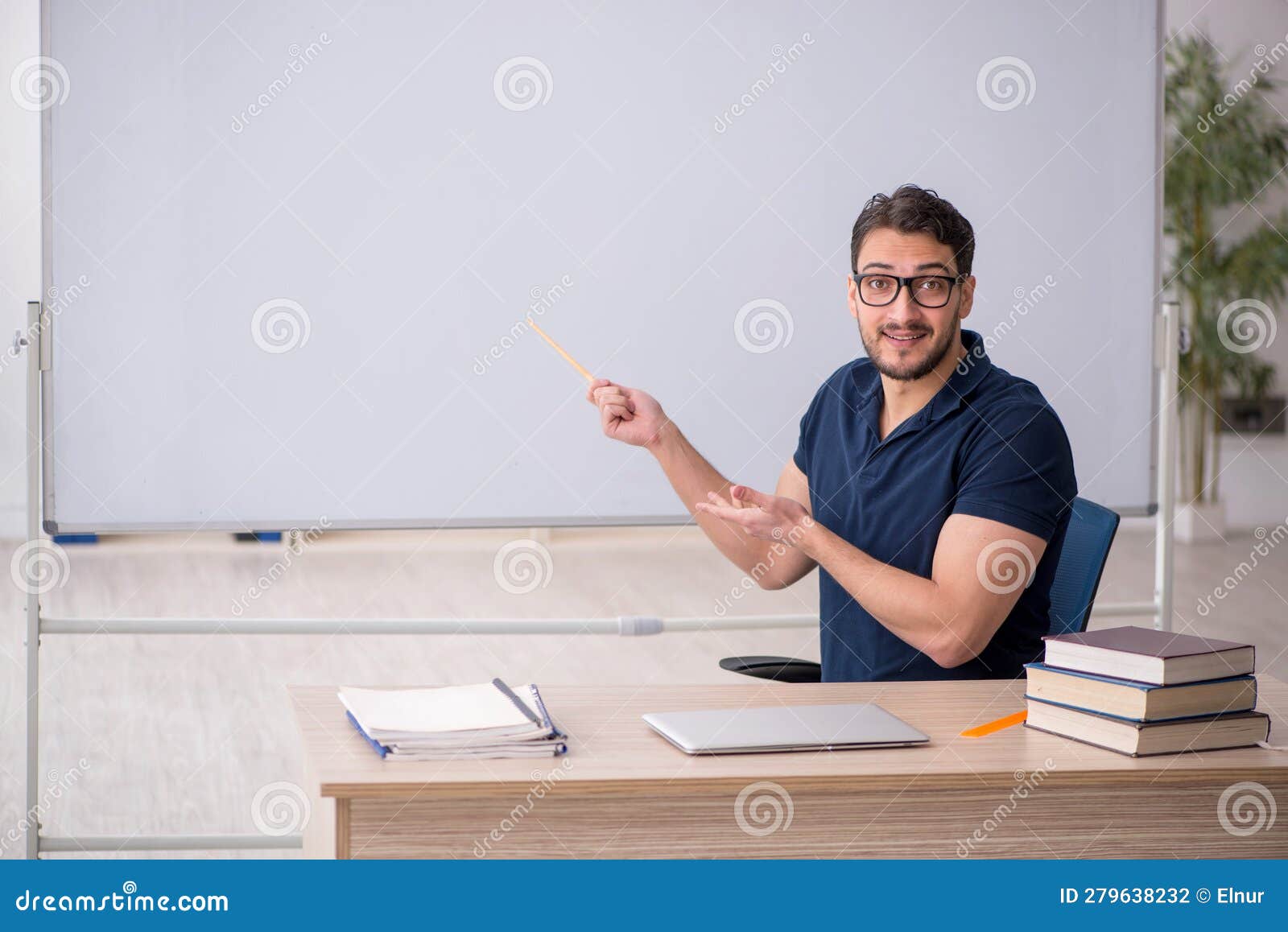 Young Male Teacher Sitting in the Classroom Stock Photo - Image of ...