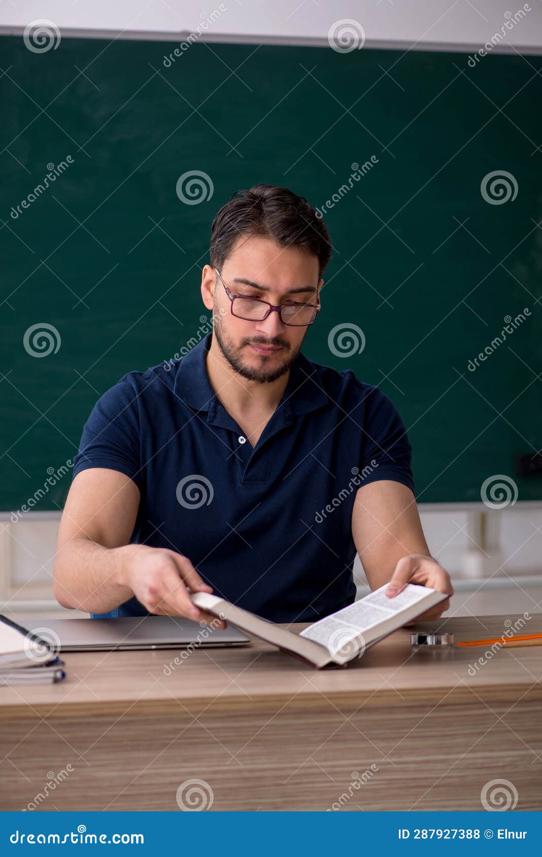 Young Male Teacher Sitting in the Classroom Stock Photo - Image of ...