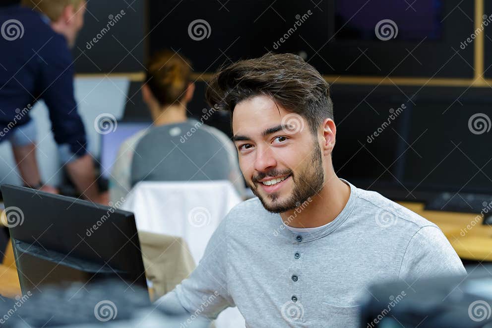 Young Male Trainee Sat at Computer Desk Stock Image - Image of ...