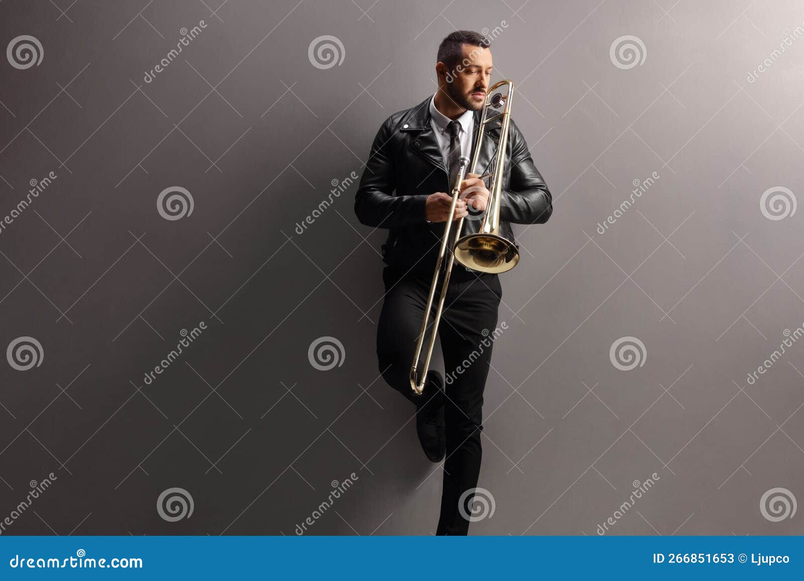 Young Male Trombone Player Standing and Leaning on a Wall Stock Image ...