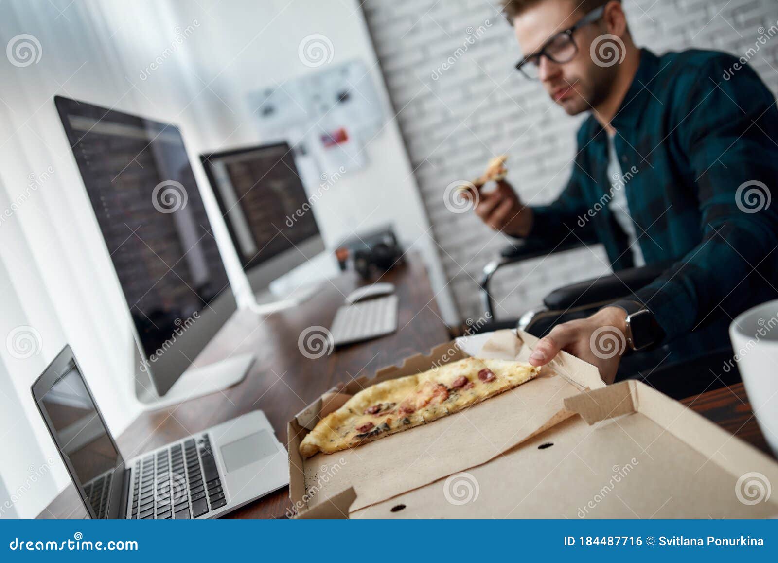 Time for a Break. Young Male Web Developer in a Wheelchair Eating Pizza ...