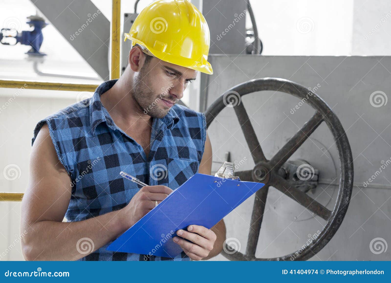 Young Male Worker Writing on Clipboard by Large Valve in Industry Stock ...