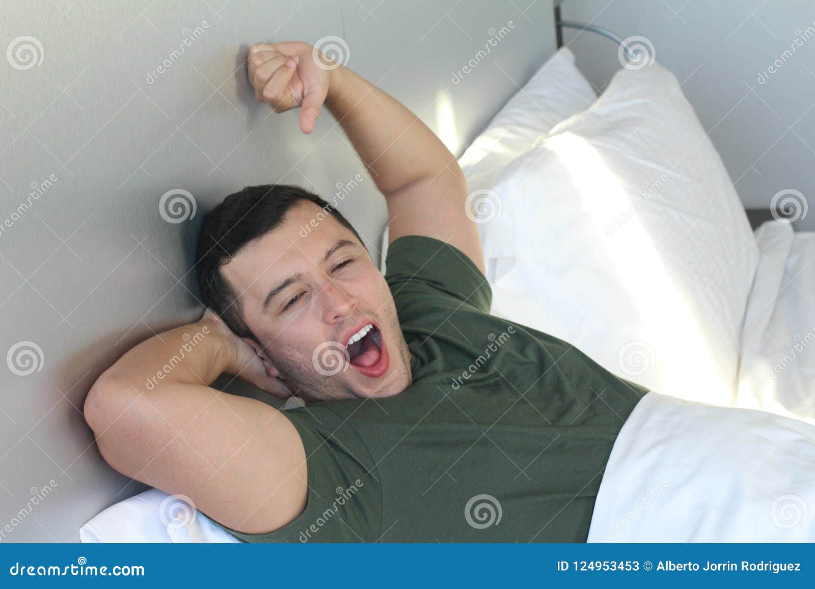 Young male yawning in bed stock image. Image of chilean - 124953453