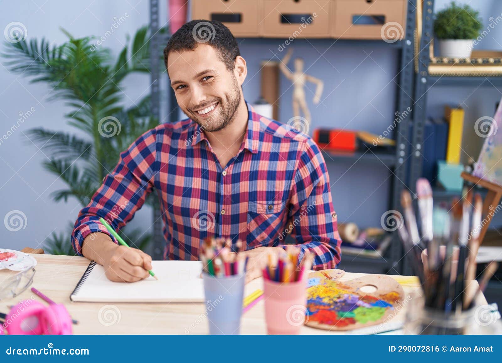 Young Man Artist Smiling Confident Drawing on Notebook at Art Studio ...