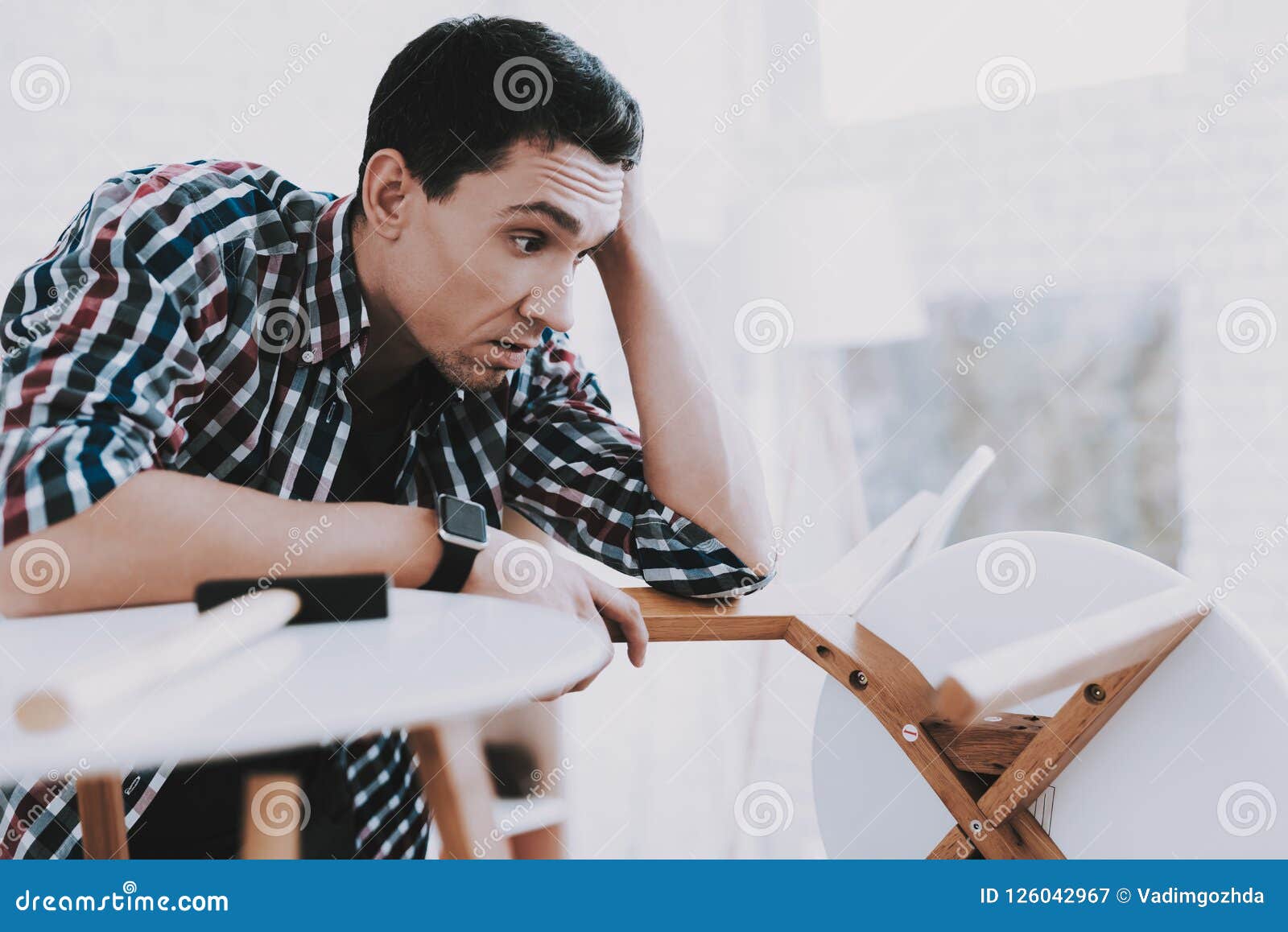 Young Man Assembling Coffee Table and Stools. Stock Image - Image of ...