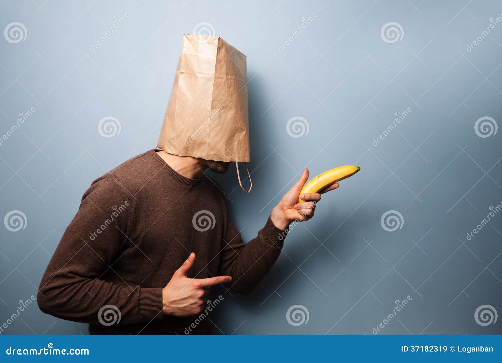Young Man with Bag Over His Head Using Banana As Gun Stock Image ...