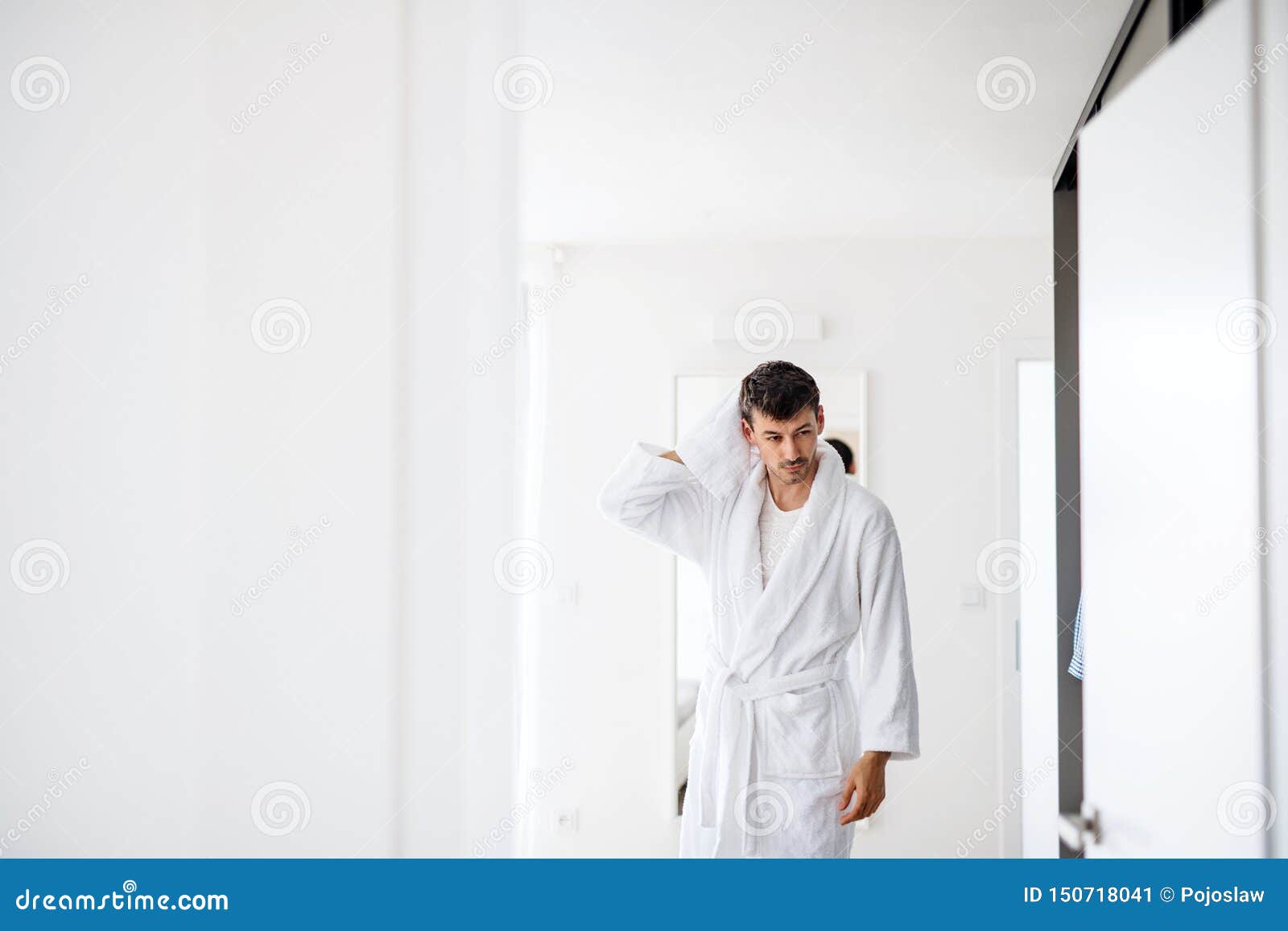 Young Man with Bathrobe in the Bedroom, a Morning Routine. Stock Image ...
