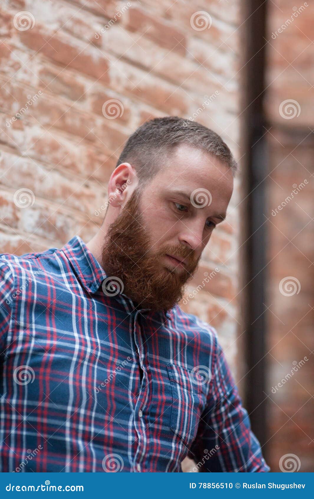 Young Man with Beard Against the Backdrop of a Brick Wall Stock Photo ...