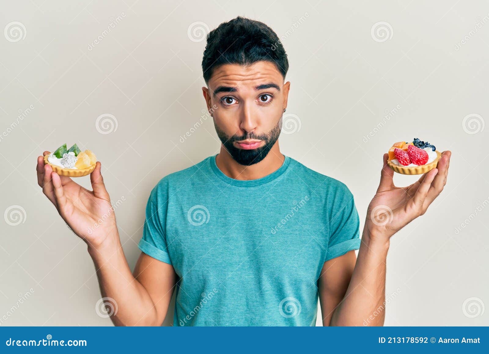 Young Man with Beard Holding Cakes Depressed and Worry for Distress ...