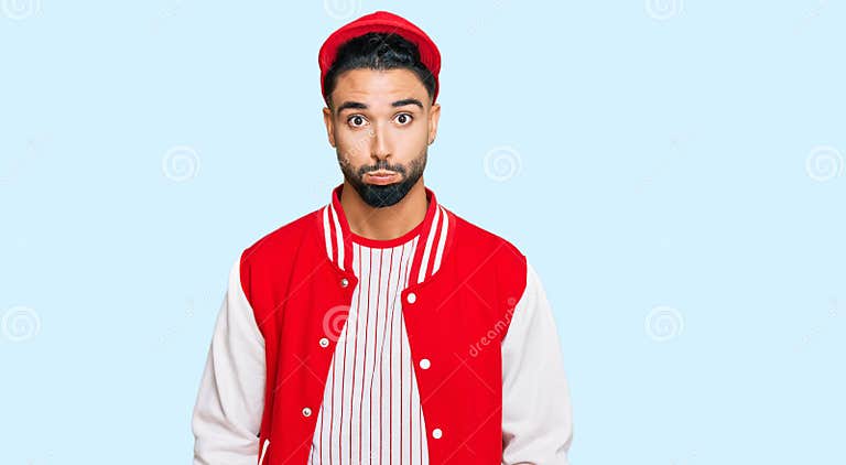 Young Man With Beard Wearing Baseball Uniform Puffing Cheeks With Funny