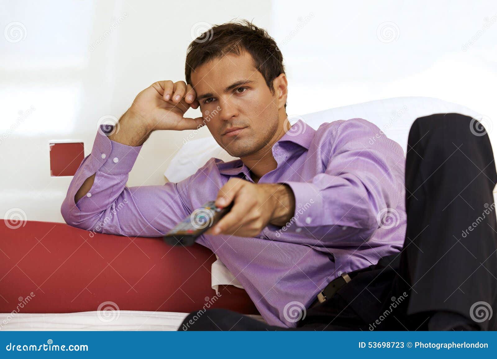 Young Man on Bed Using Remote Control Stock Image - Image of resting ...