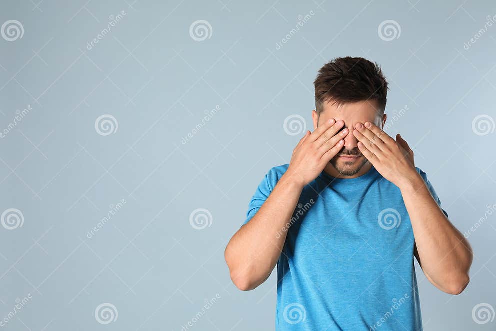 Young Man Being Blinded on Grey Background Stock Photo - Image of ...
