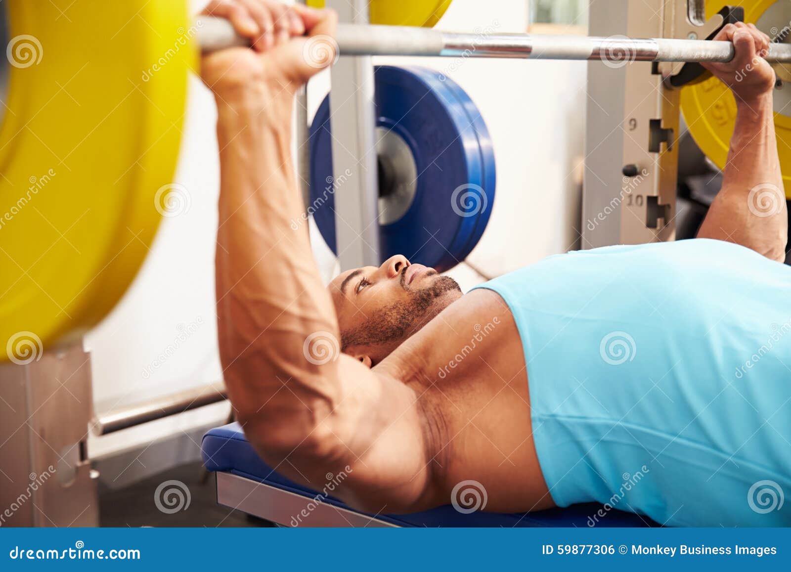 Young Man Bench Pressing Weights at a Gym, Side View Close-up Stock ...