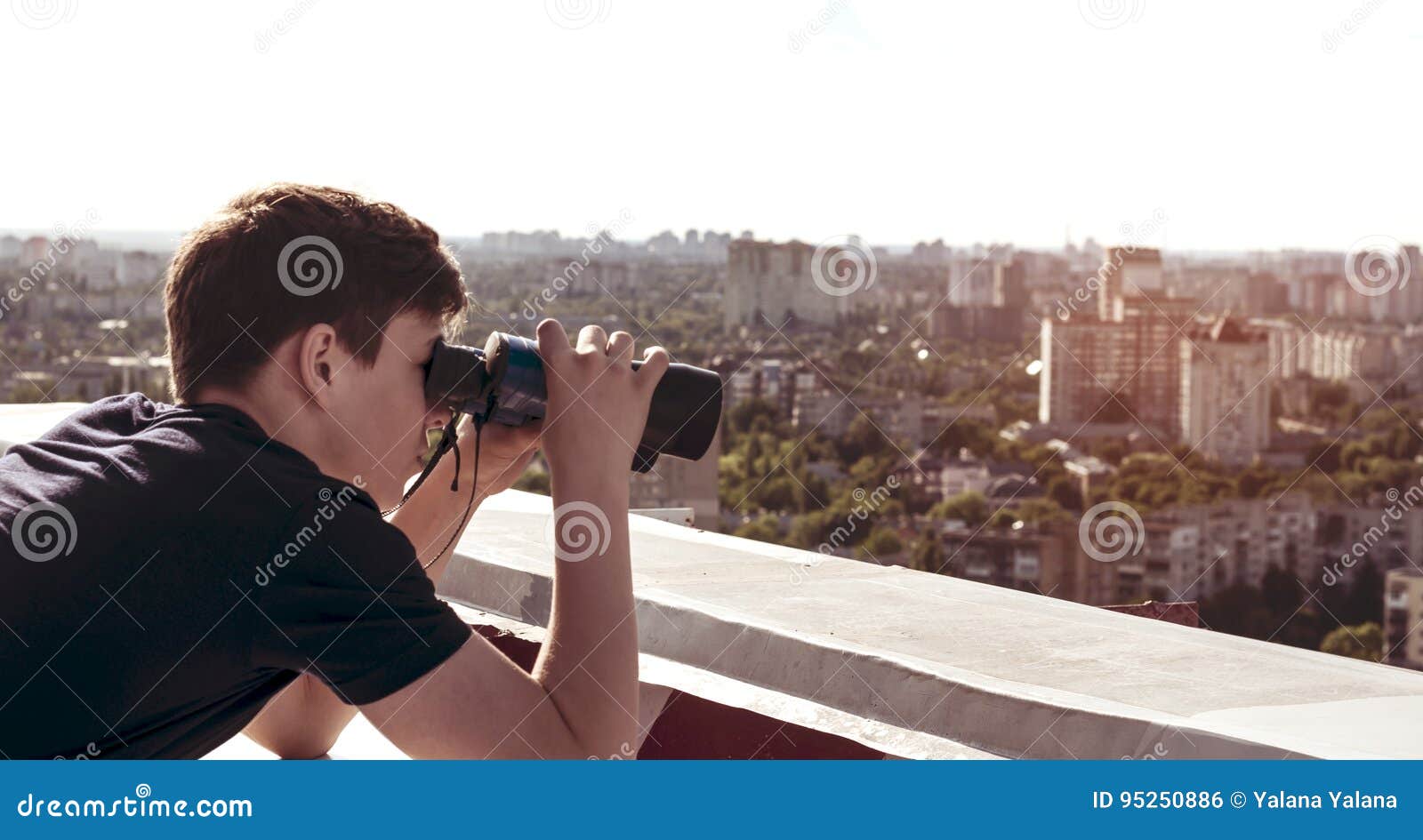 A Young Man with Binoculars Watching from the Roof of the House Stock ...