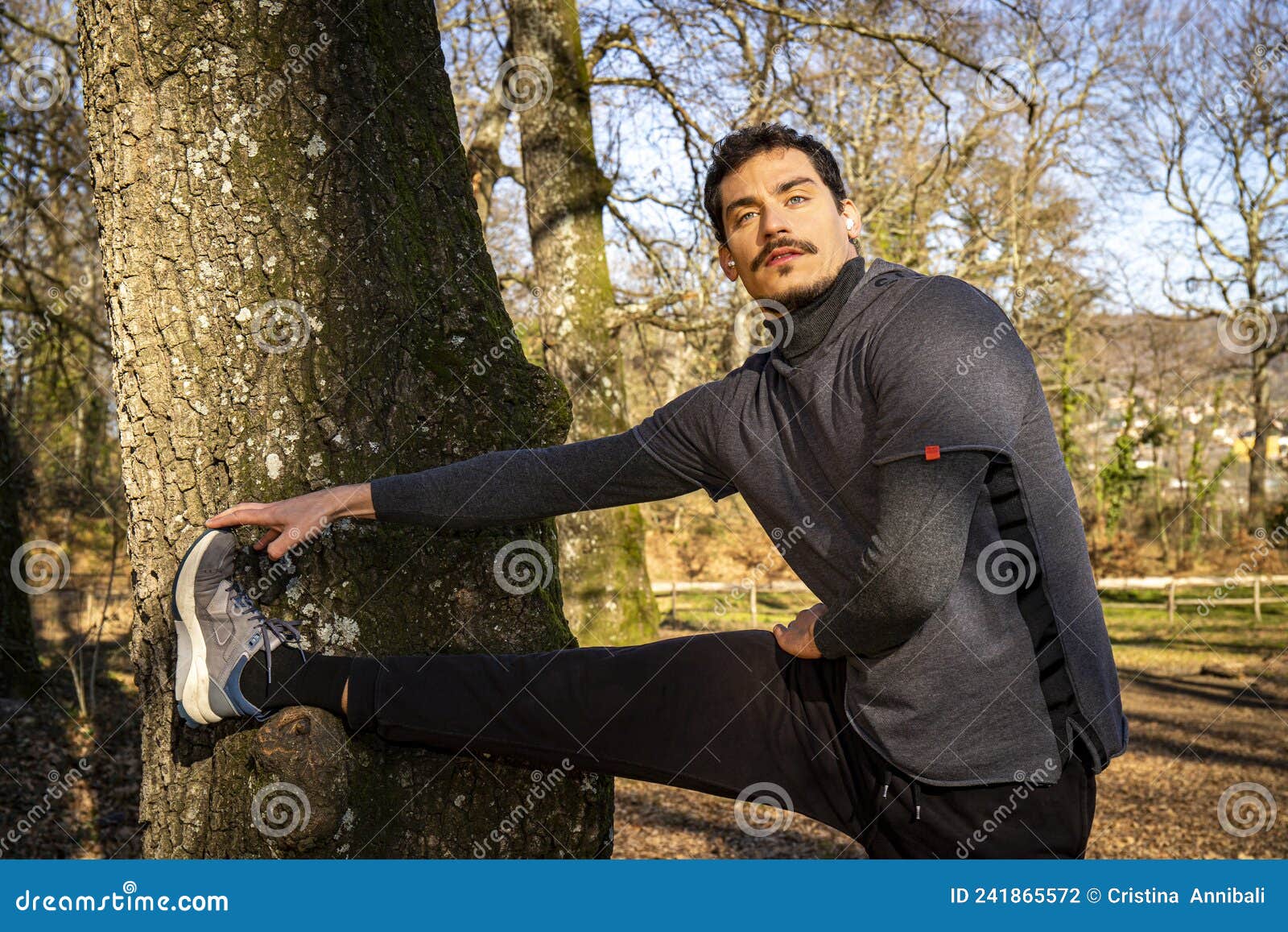 The Runner is Leaning Against an Oak Tree and is Stretching. Stock ...