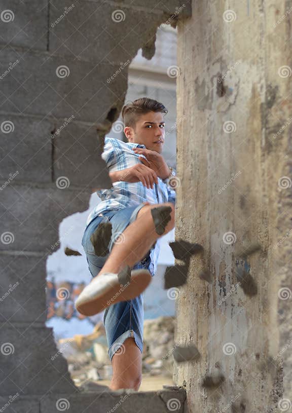 Young Man Breaking through Wall with a Kick Stock Image - Image of ...