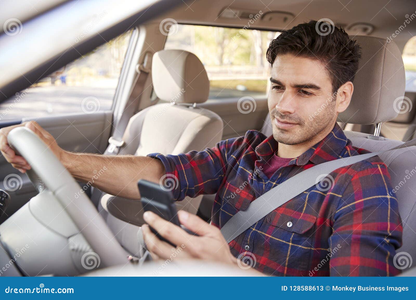 Young Man in Car Checking His Smartphone while Driving Stock Image ...