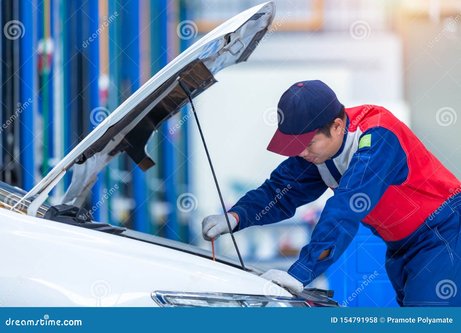 Young Man Car Mechanic in a Car Repair Service Center is Analyzing ...