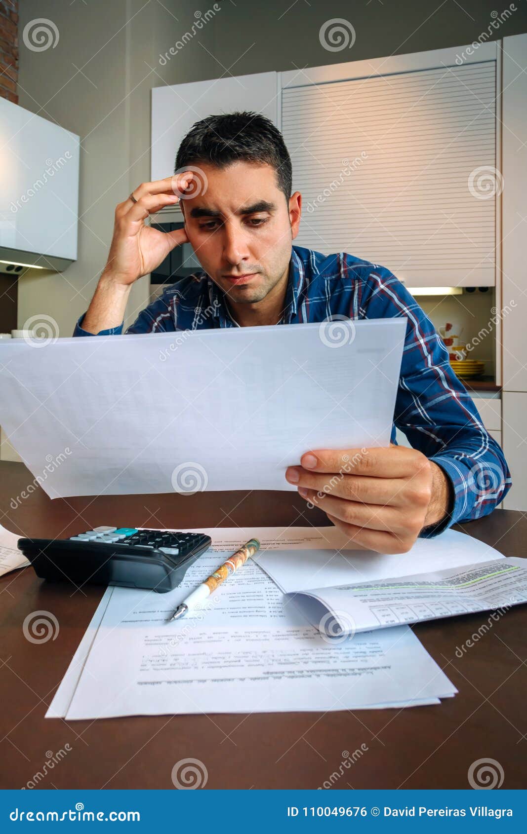 Young man checking bills stock photo. Image of kitchen - 110049676