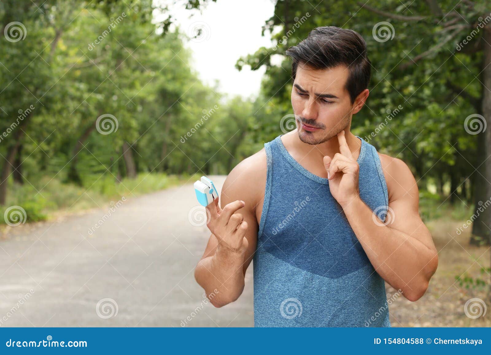 Young Man Checking Pulse with Medical Device after Training in Park ...