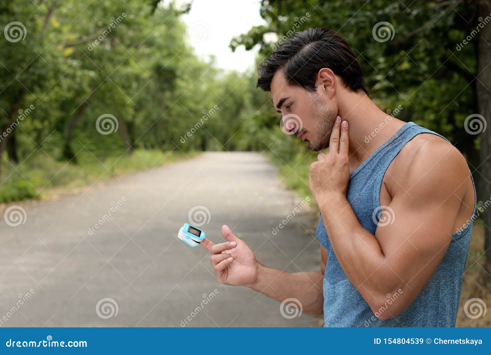 Young Man Checking Pulse with Medical Device after Training in Park ...