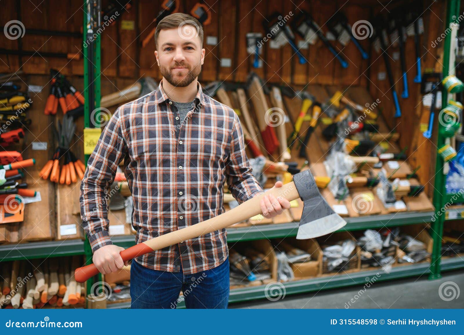 A Young Man Chooses Axe in the Hardware Store Stock Photo - Image of ...
