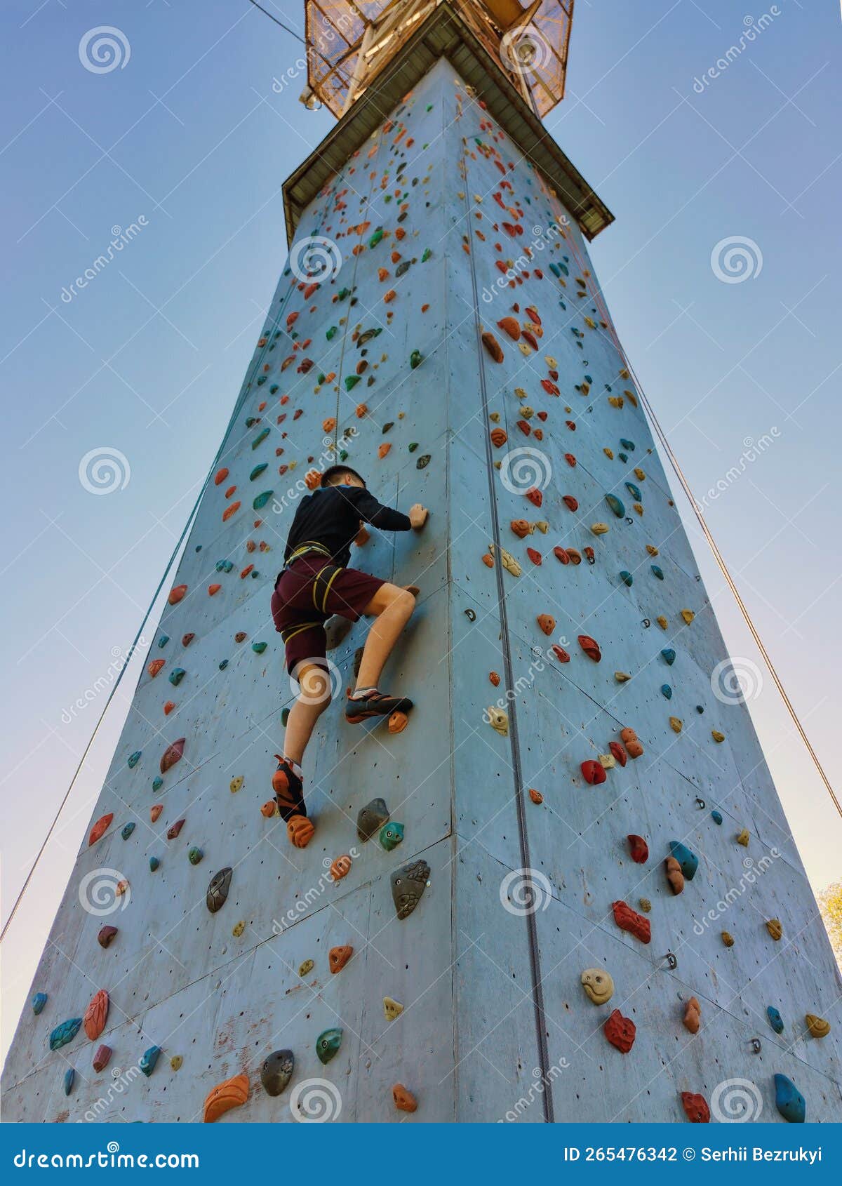 A Young Man Climbs the Wall for Climbing in Special Equipment. View from Below Stock Photo ...